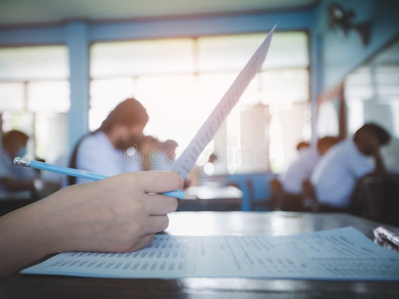 Close Up Hand of Student Reading and Writing Exam Answer Sheets ...