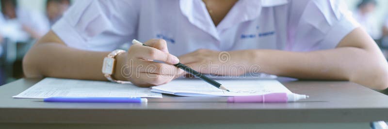 Close Up Hand of Student Reading and Writing Exam Answer Sheets ...