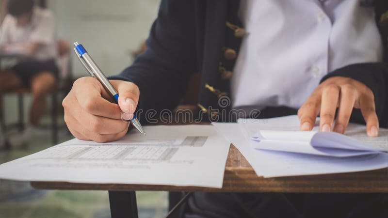 Close Up Hand of Students Reading and Taking Exam Sheets Exercises ...