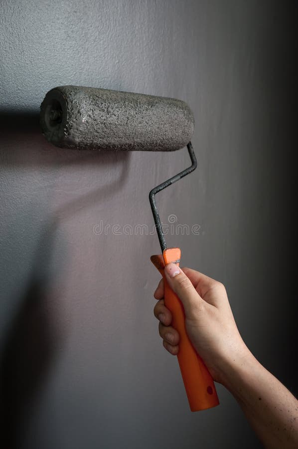 Close Up of Hand Using Paint Roller Applying Grey Paint on Wall. Stock ...
