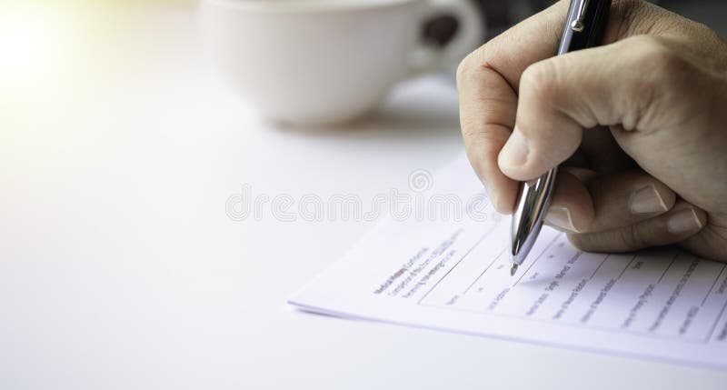 Close-up of Hand Using Writing Pen with Questionnaire or Paperwork ...