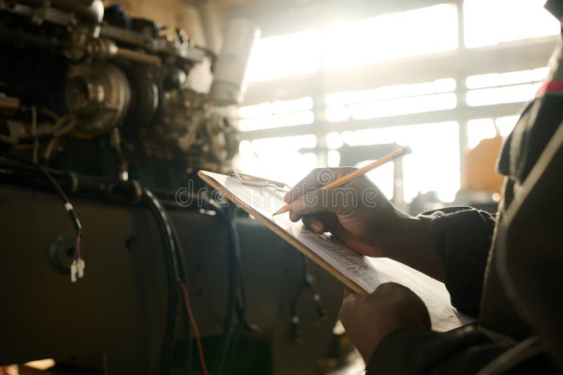 Close-up of Hand of Young Engineer with Pencil Making Notes in Document ...
