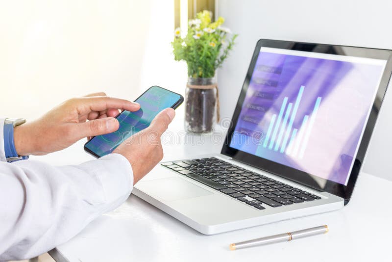 Close-up of Hands with a Cell Phone with a Computer in the Background ...