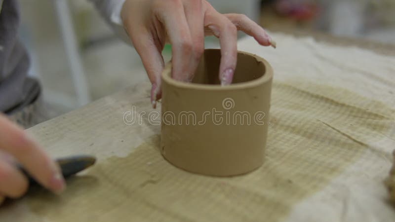 A Close-up of the Hands of a Child Who Sculpts a Mug from Clay at a ...