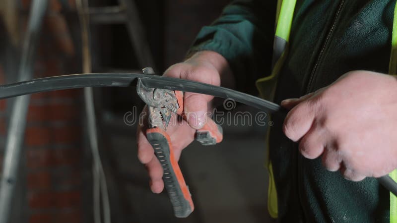 Close-up of Hands Cutting Electrical Cable with Tool, Worker Using a ...