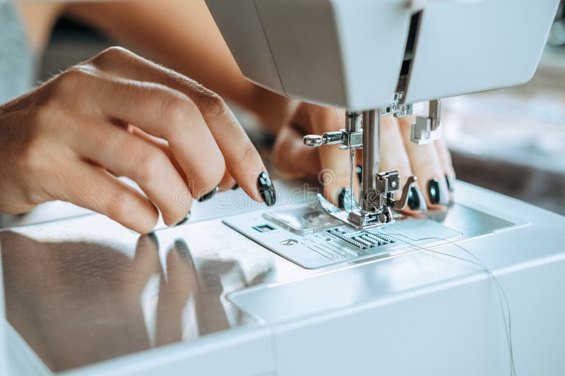 A Close-up of the Hands of a Female Seamstress Threading a Sewing ...