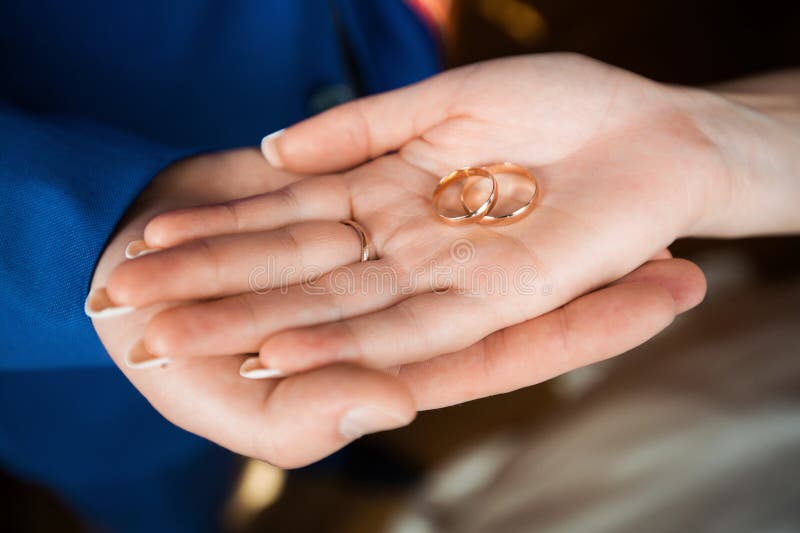 Close-up of Hands Holding Two Gold Wedding Rings Stock Photo - Image of ...