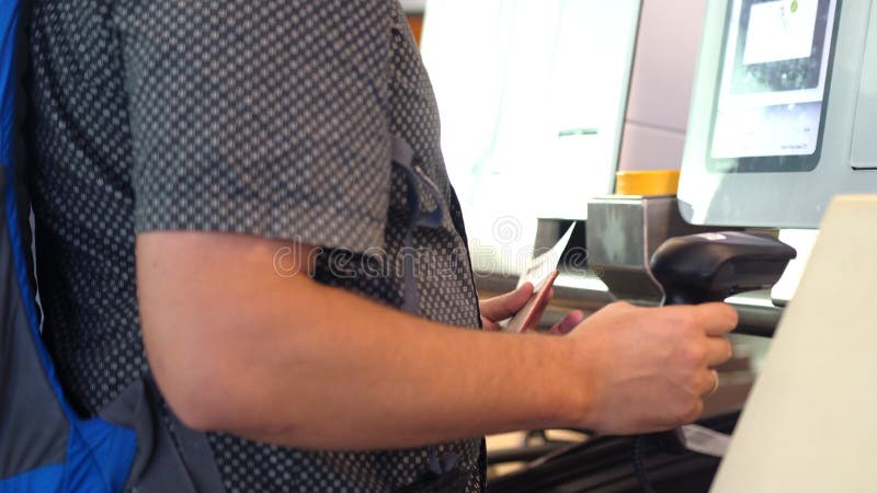 Close Up of Hands Holds Passport. Check-in at Self Help Desk in the ...