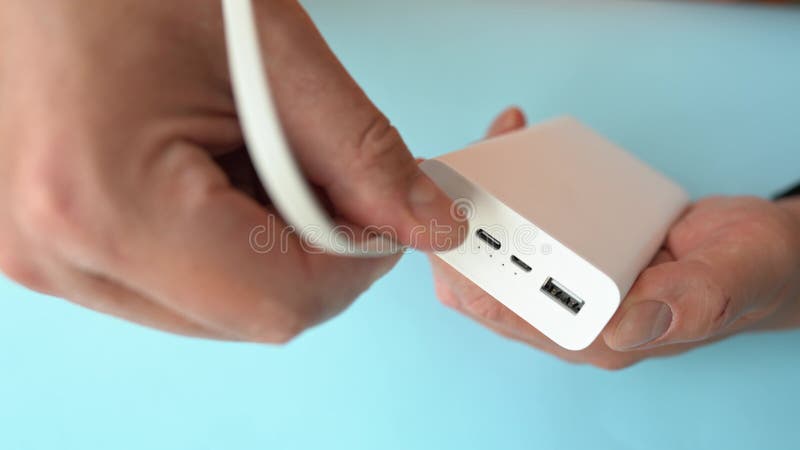 Close-up Hands of the Man is Holding Charger and Inserts the Cable into ...