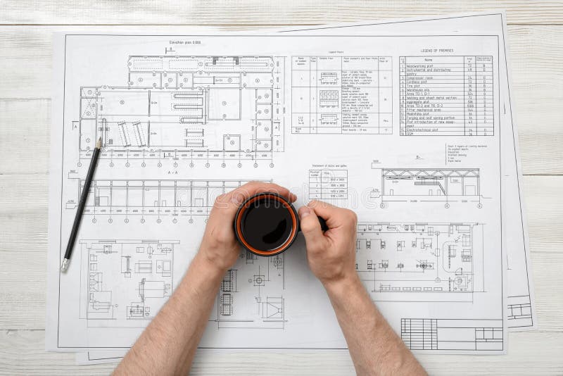Close-up Hands of Man Holding Cup Coffee Over Drawing Layout in Top ...