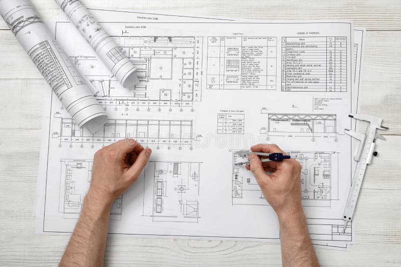 Close-up Hands of Man Holding an Engineering Divider Over Drawing Plan ...