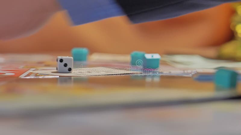 Close-up of the Hands of People Playing the Game Monopoly. Stock ...
