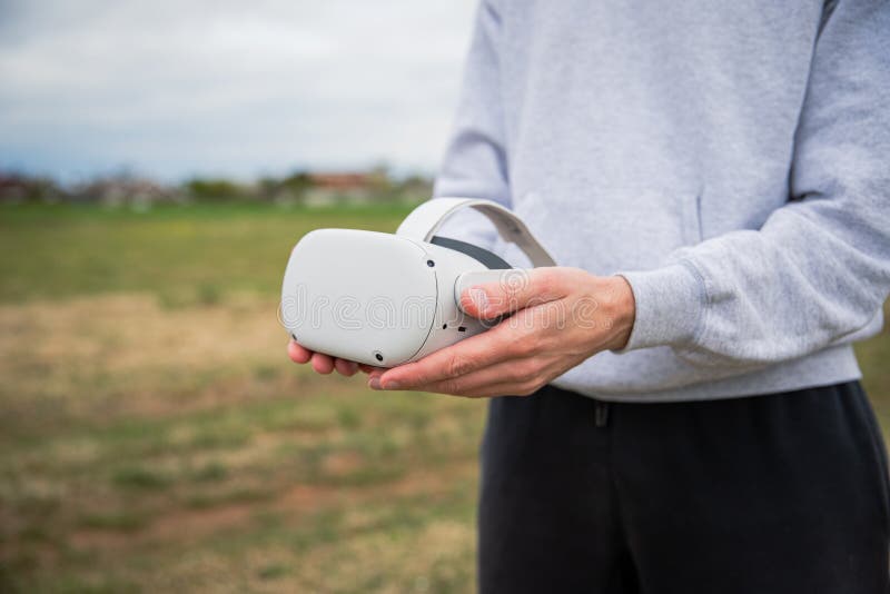 Close-up of the Hands of a Person Holding Up Virtual Reality Headsets ...