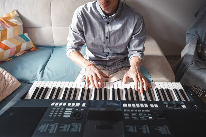 Close-up of Hands Playing a Digital Keyboard Under Warm Natural Light ...