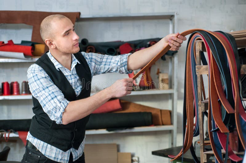 Close-up of the Hands of a Professional Craftsman Choosing a Belt in a ...