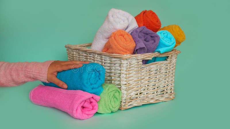 Close-up of Hands Putting Stack of Fresh Bath Towels. Multi-colored ...