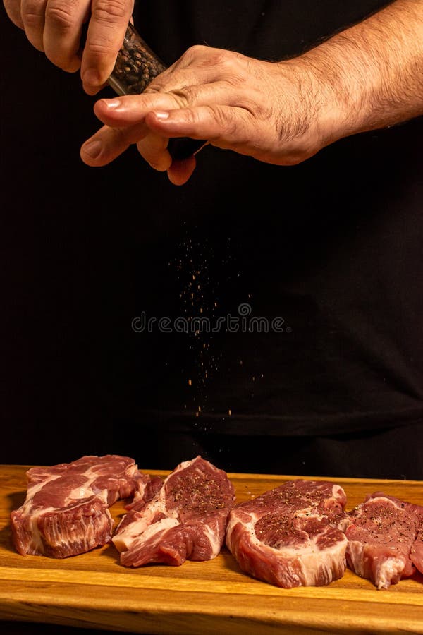 Close-up of Hands Sprinkling Pepper on Sliced Meat. Stock Photo - Image ...