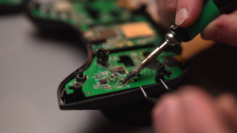 Close-up Hands of Technician Using Soldering Iron To Repair Circuit ...