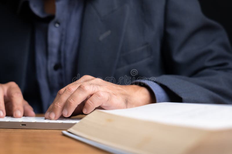 Businessman Typing on Keyboard with Open Book Reference Stock Photo ...