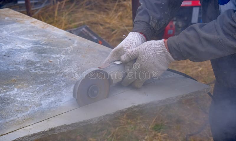 Close-up of the Hands of a Worker Sawing an Asbestos Slab on a Grinding ...