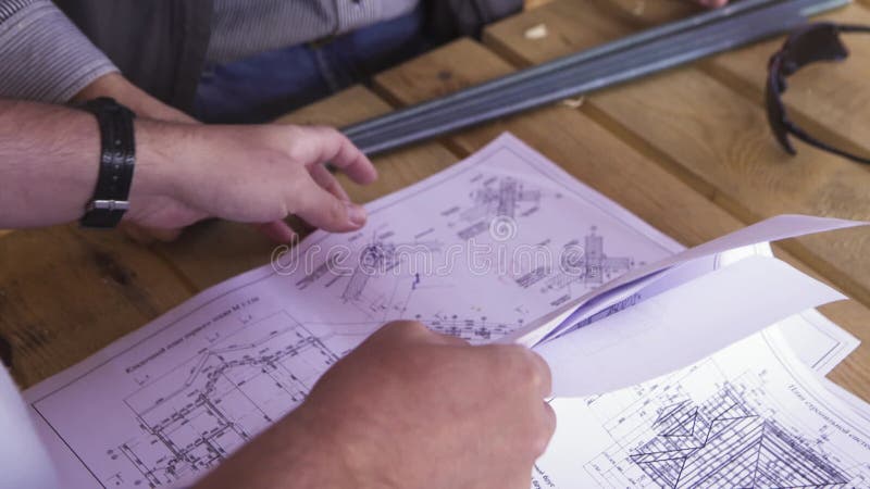 Close Up for Hands of Workers at a Factory Looking through Technical ...