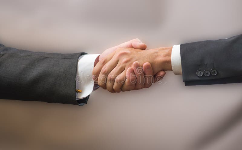 Close-up Handshake of Two Business Partners in Suits on a Gray ...