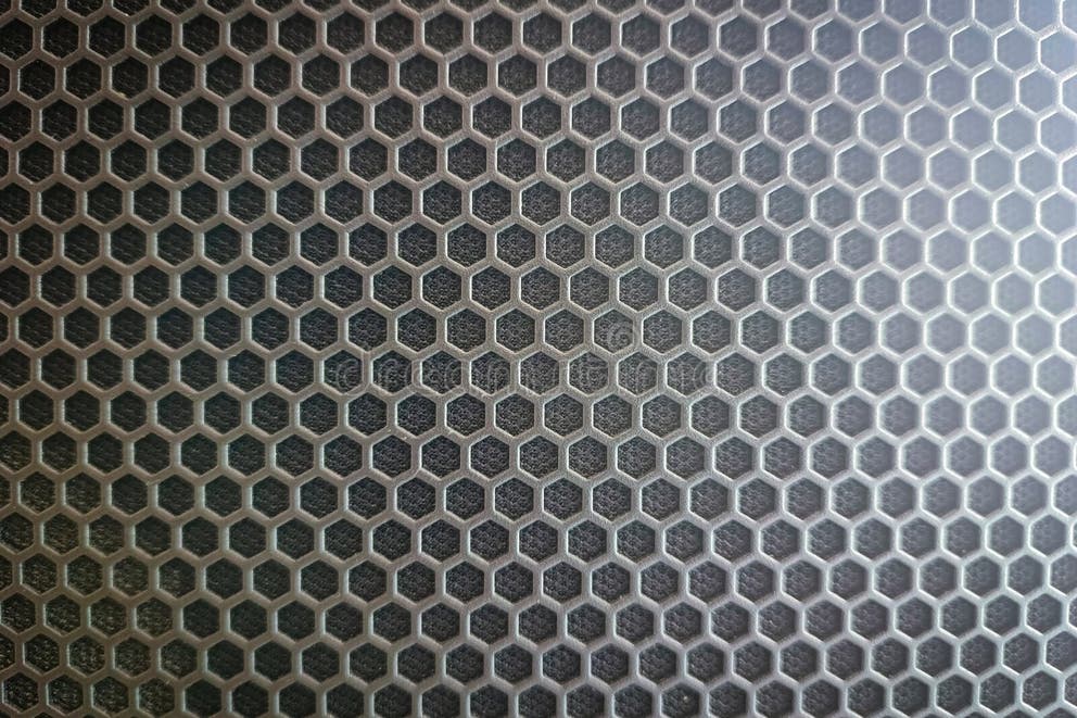 A Close-up of a Hexagonal Honeycomb Pattern on a Dark Textured Surface ...