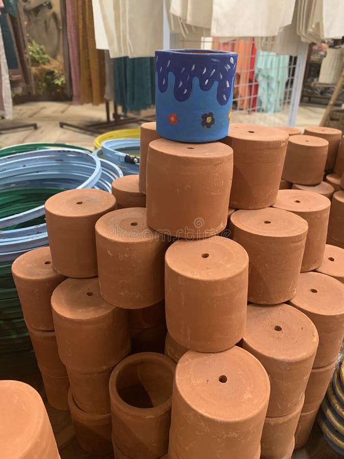 Handmade Terracotta Pots Stacked with a Playfully Painted Blue Pot on ...