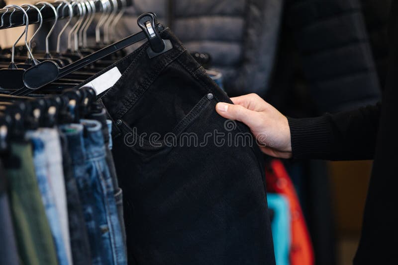 Close Up of Human Hand Taking Black Jeans. Trousers for Man Stock Image ...
