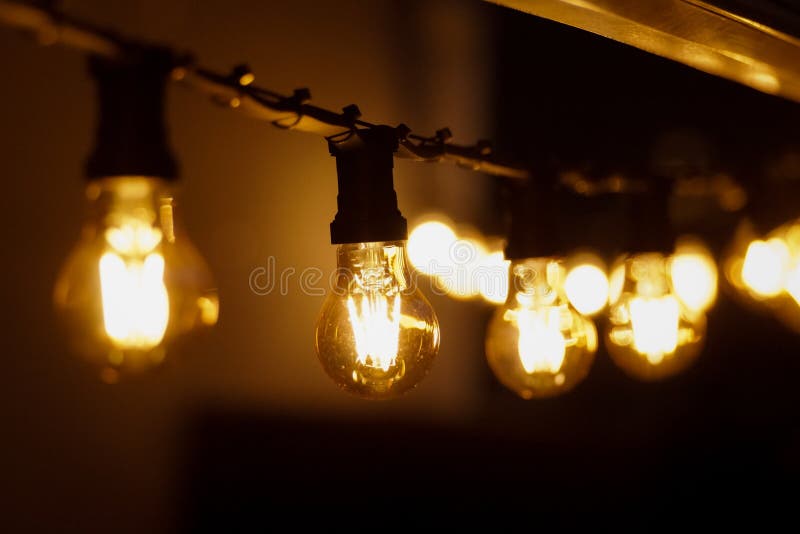 Close Up of Illuminated Light Bulbs Hanging Stock Image - Image of dark ...