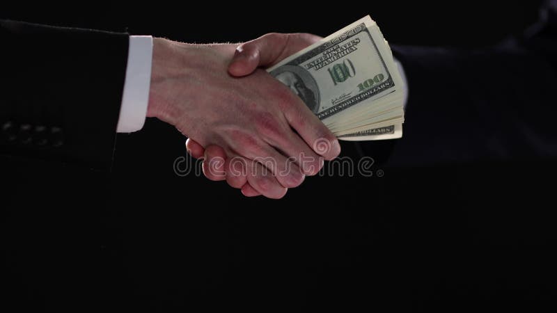 Handshake with the Transfer of Money on a Black Background Stock ...