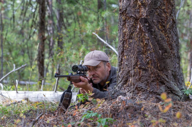 Close-up Image of Hunter with Rifle Lying Behind Tree Stock Image ...