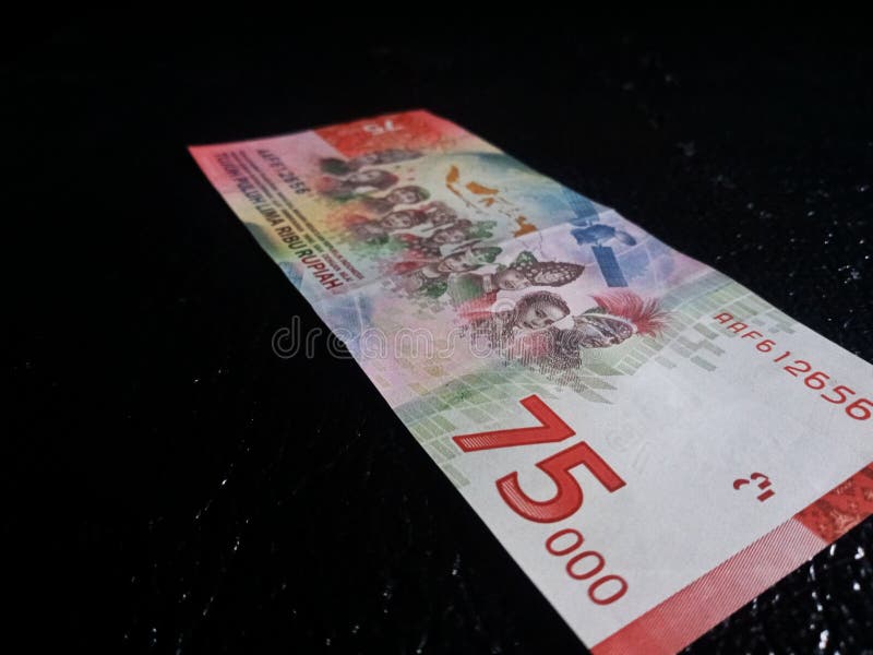 Close-up of an Indonesian Currency, 75.000 Rupiah on a Black Surface ...