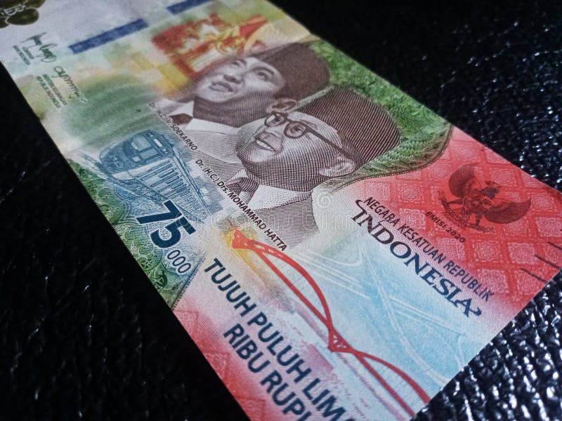 Close-up of an Indonesian Currency, 75.000 Rupiah on a Black Surface ...