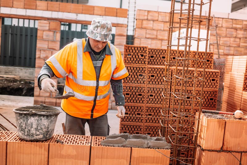 Industrial Bricklayer Installing Bricks on Construction Site Stock ...