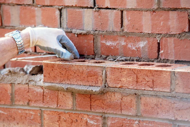 Industrial Bricklayer Laying Bricks on Cement Mix on Construction Site ...