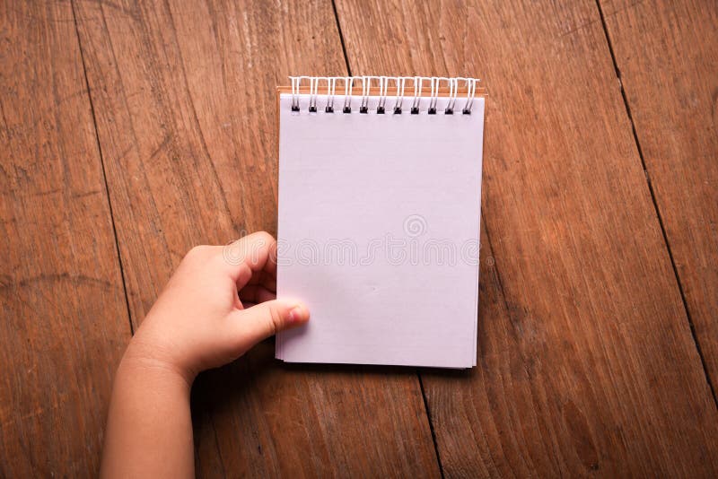 Close Up Kid Hand Holding Notebook Paper on Table Wood Background ...
