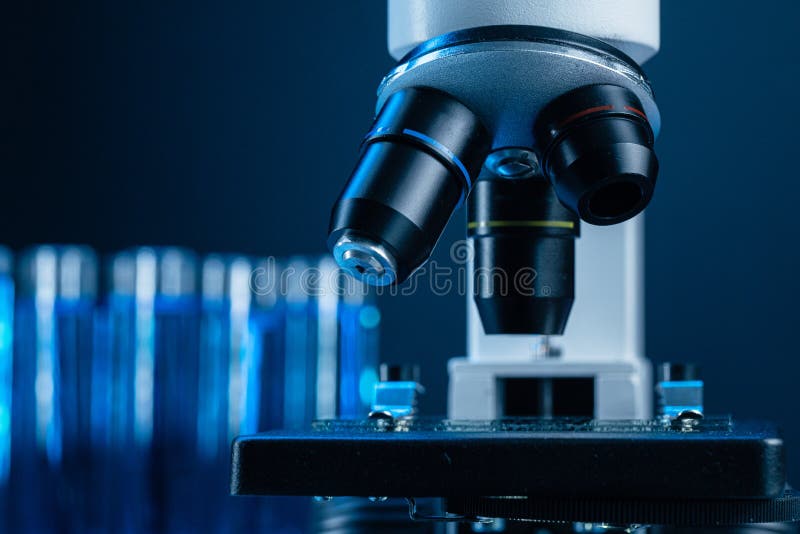 Close Up of Laboratory Microscope with Set of Test Tubes with Blue ...