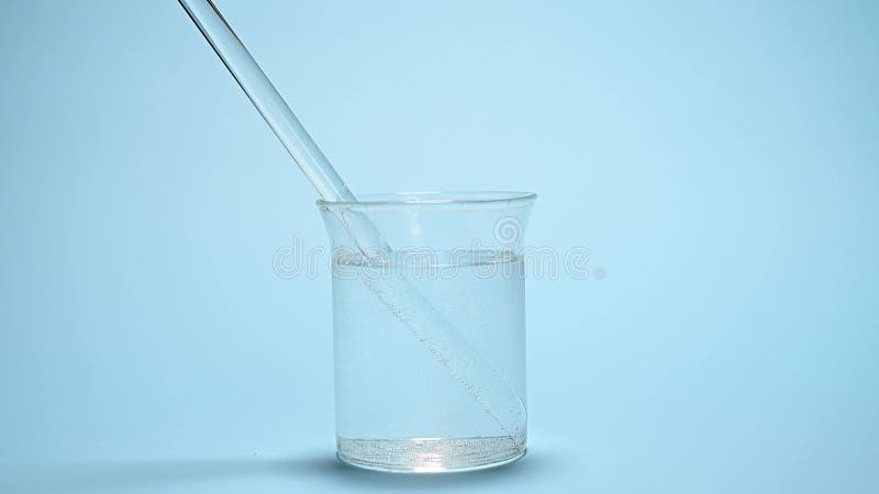 Close-up Laboratory Stick Inside a Glass of Water with Bubbles after ...