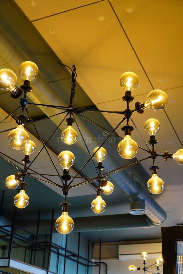 Close Up of Lamp with Many Bulbs in Cafe Interior. Pipes Covered with ...