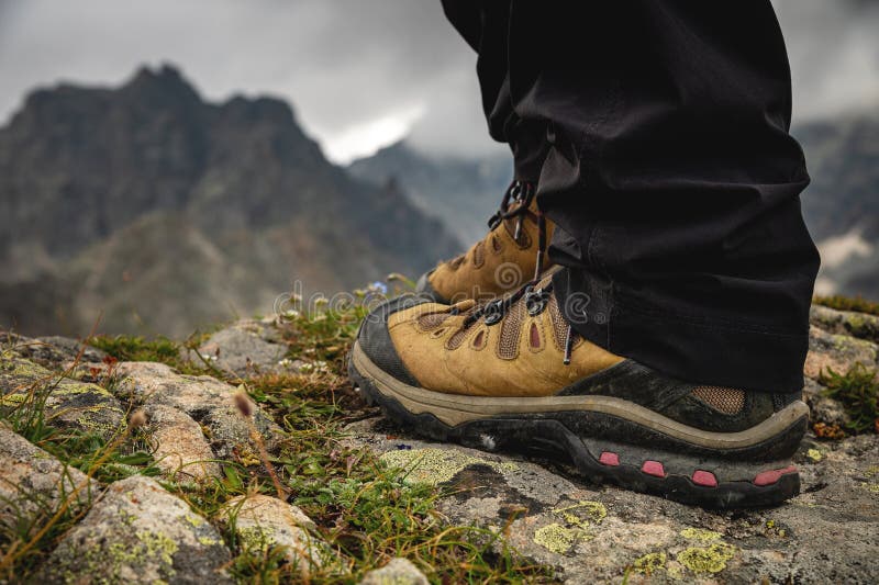 Close-up of Legs in Trekking Boots Against the Backdrop of an Alpine ...