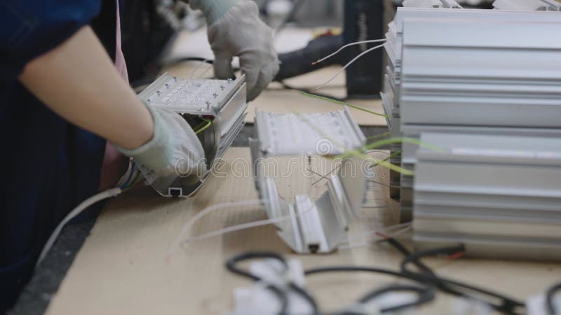 Close-up of a Lighting Factory. a Worker Manually Assembles an Electric ...