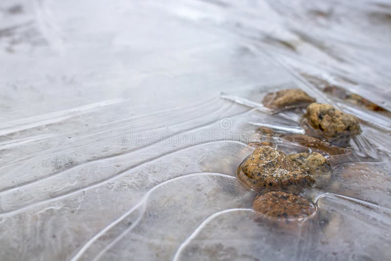 Close Up Lines in Ice with Rocks Stock Photo - Image of background ...