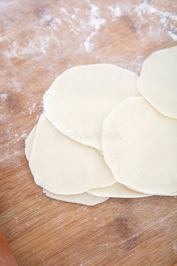 Close-up Looking Down on White Flour Dumpling Wrappers on Cutting Board ...