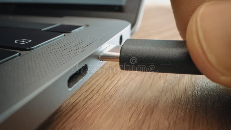 Close-up Macro Shot: Laptop on the Desk, Person Inserts USB-C Cable ...