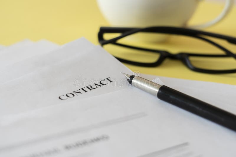 A Close Up Macro View of a Contract Document with Eye Glasses and a Pen ...
