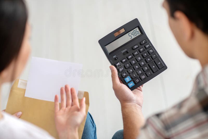 Close-up of Male and Female Hands Holding Calculator and Envelope Stock ...