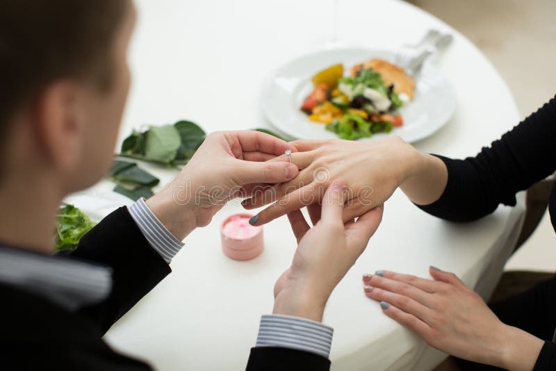 Close Up of Male Hand Inserting an Engagement Ring into a Finger. Stock ...