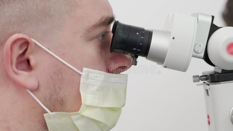 Close-up of Male Scientist in Protective Face Mask Using Microscope in ...
