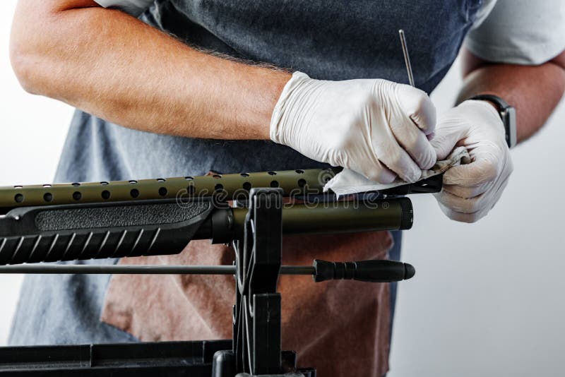 Close Up of a Man in Apron Wiping His Firearm with a Cloth Stock Photo ...